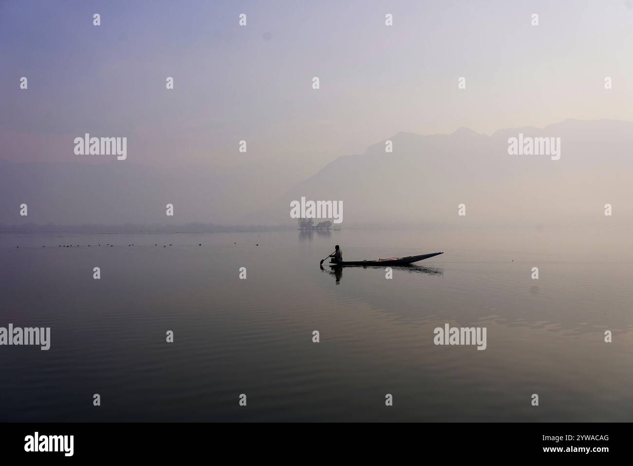 Srinagar, India. 10th Dec, 2024. A Kashmiri boatman rows his boat across the world famous Dal ...