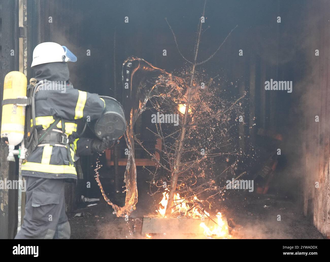 Hamburg, Germany. 10th Dec, 2024. A firefighter extinguishes a burning ...