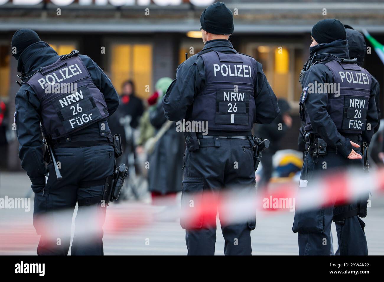 Duisburg, Germany. 10th Dec, 2024. Police officers stand behind a tape barrier at Duisburg main ...