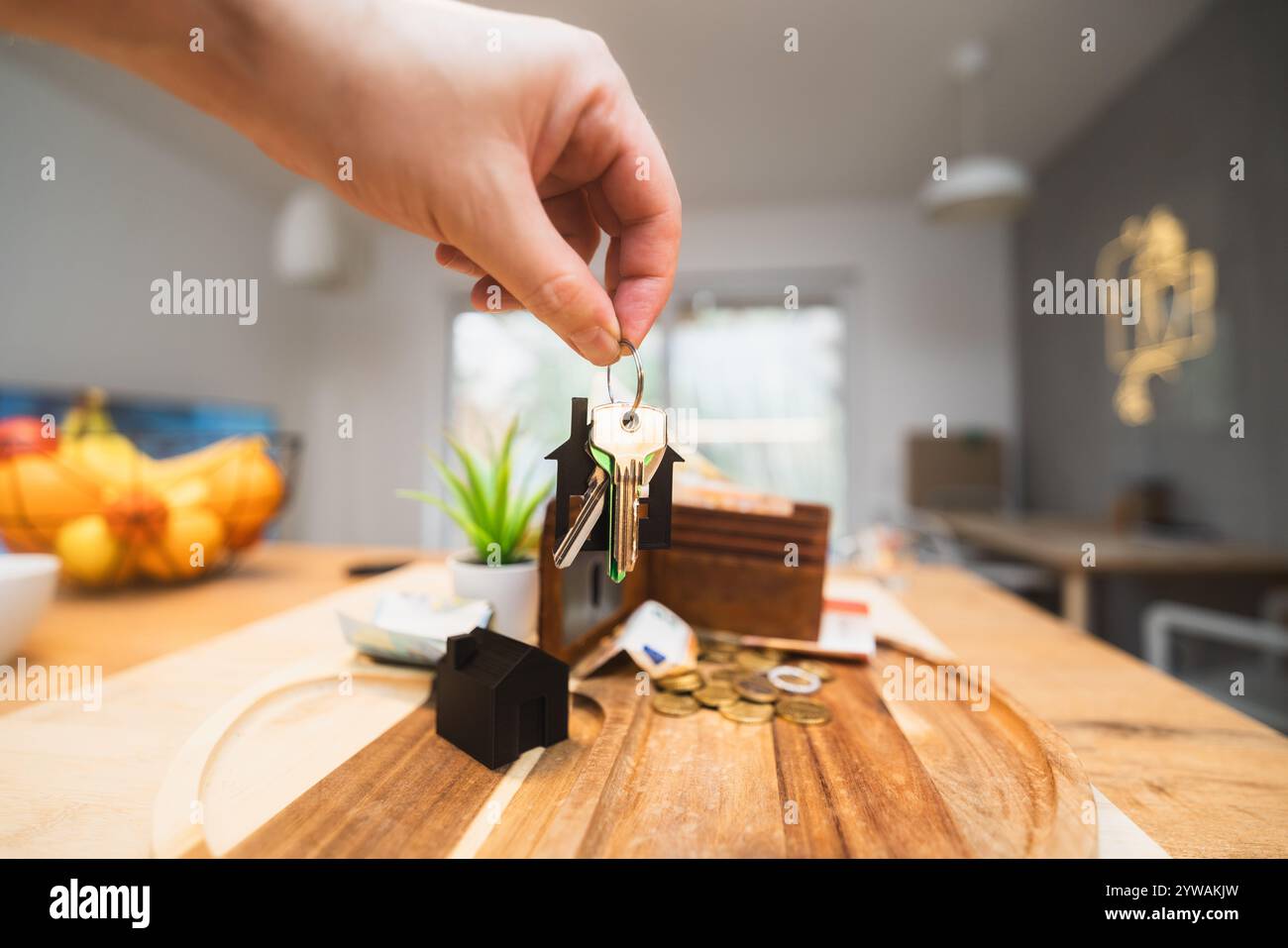 Hand holding door keys living room interior money wallet new home ...