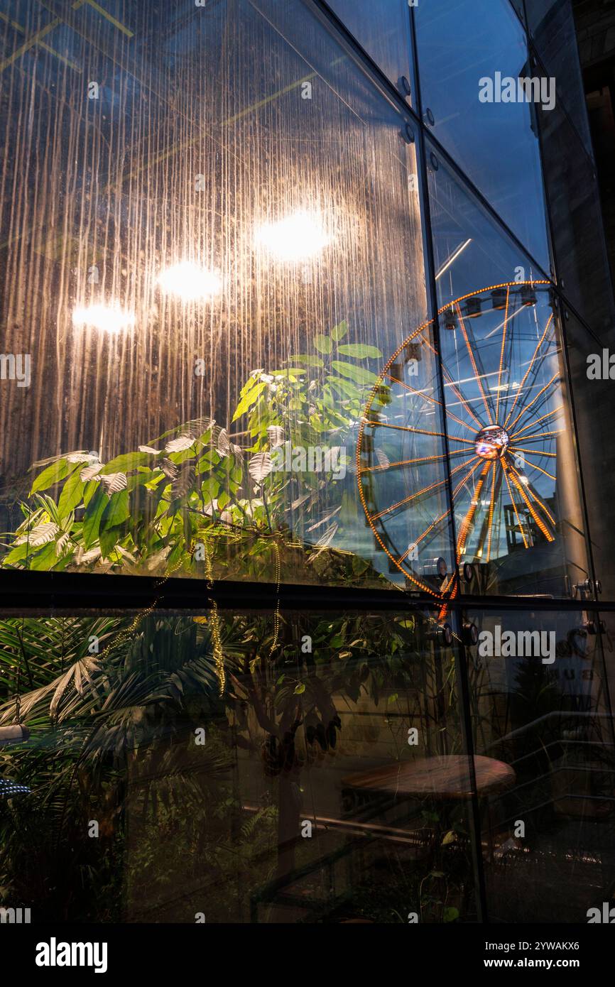 the ferris wheel in Rheinau harbour is reflected in the window of the ...
