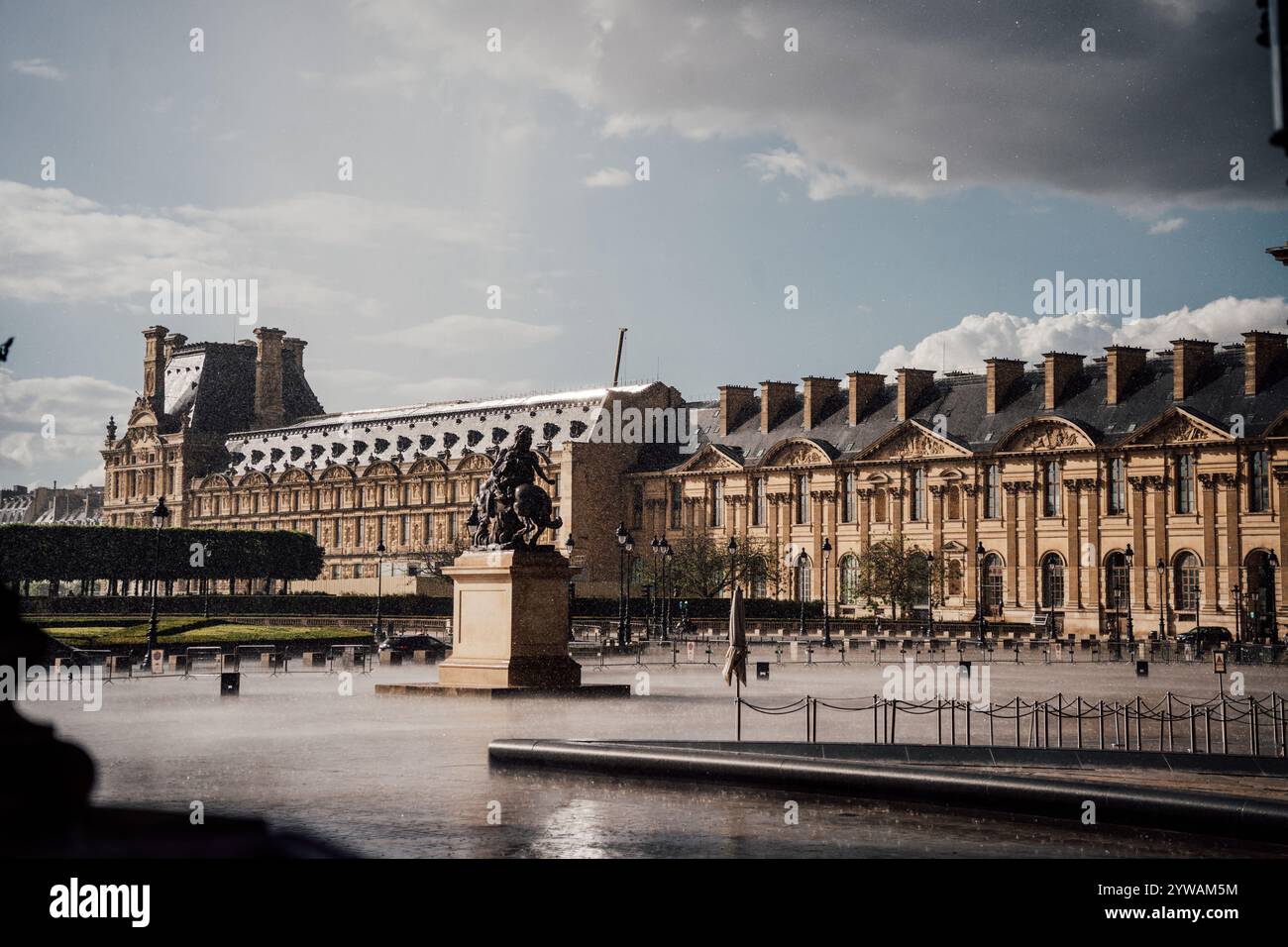 Louvre pyramid under the sun with the ground wet after a day of rain ...