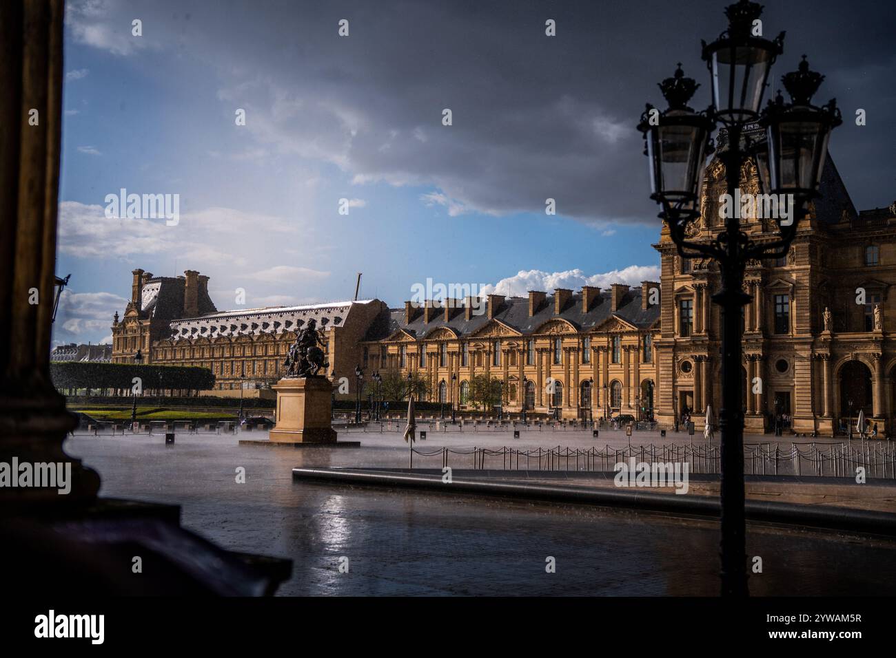 Louvre pyramid under the sun with the ground wet after a day of rain ...