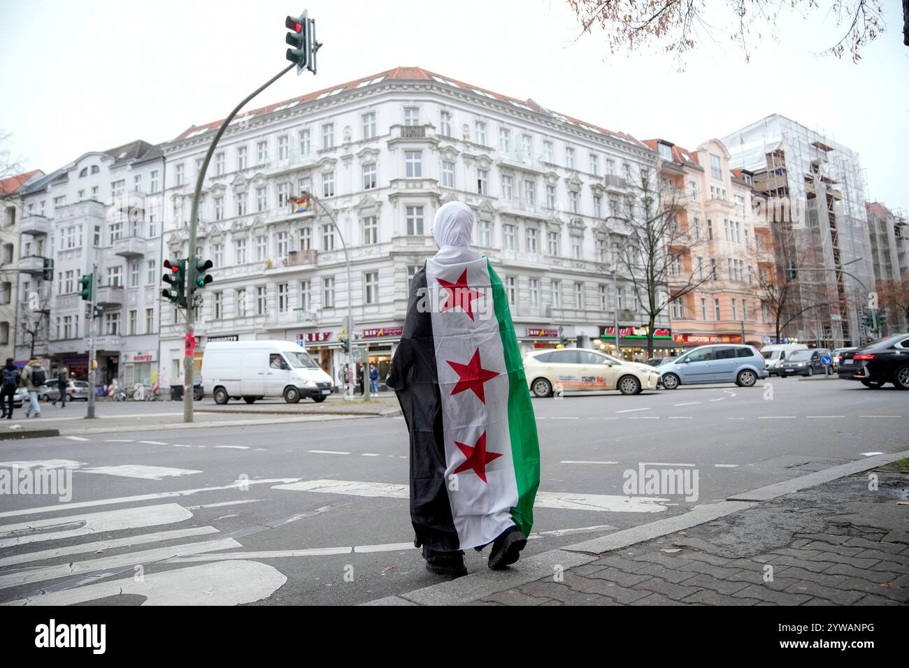 A Syrian girl walks down a street in Berlin while wearing a Syrian ...