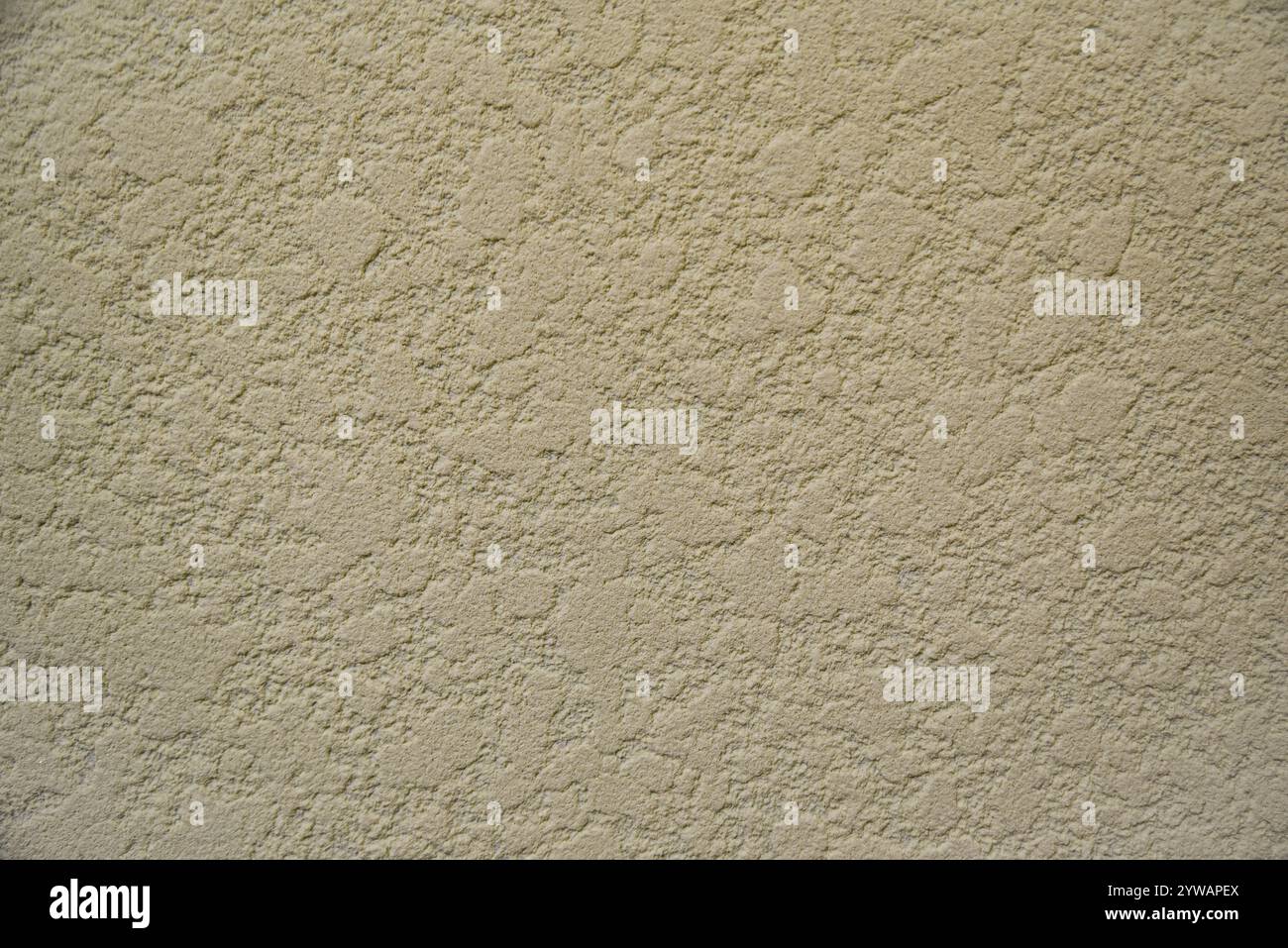 A wall with a textured surface. The wall is tan in color. The texture ...