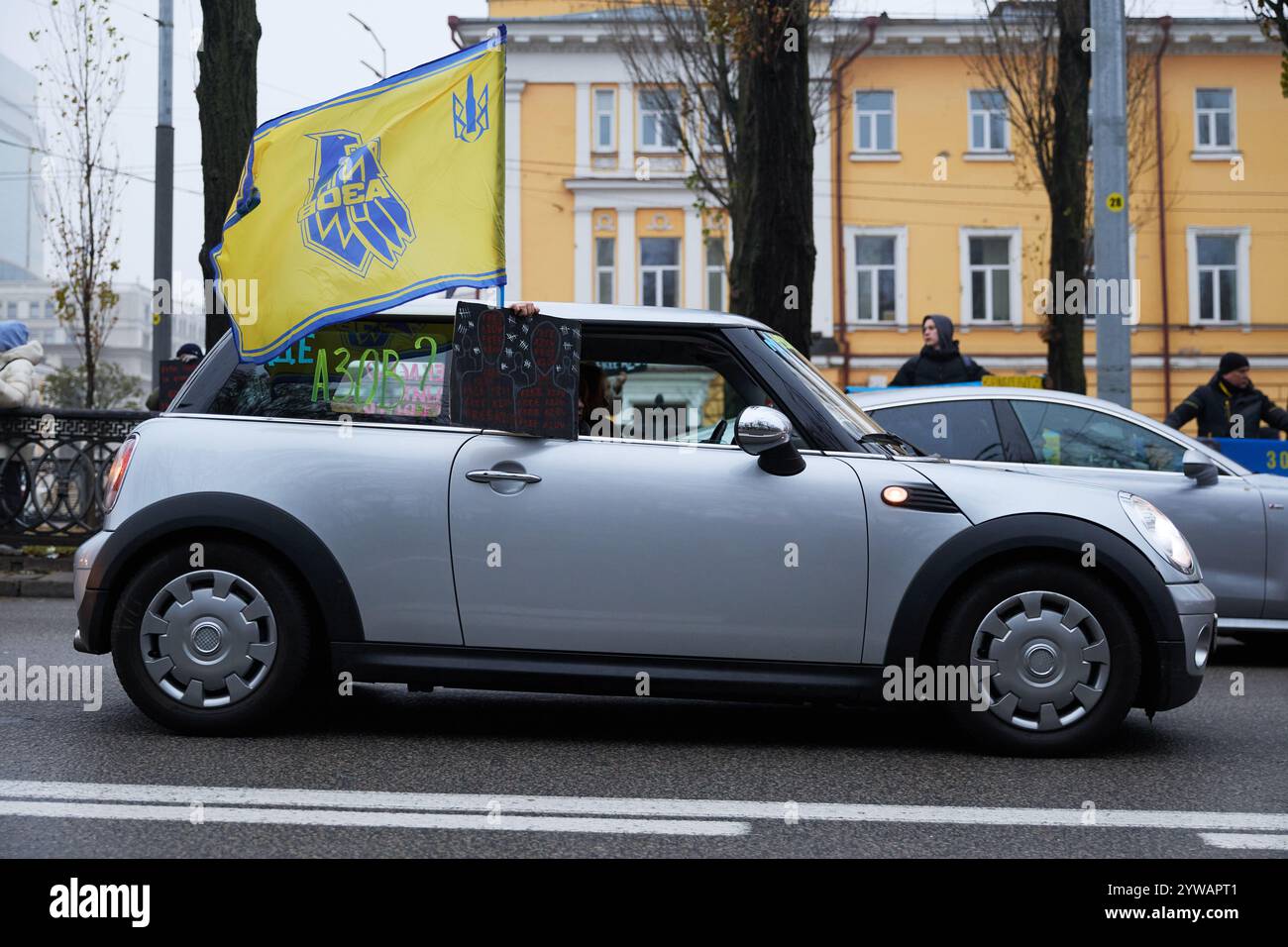 Ukrainian acitivist rides in a car with flag of Azov brigade in center ...