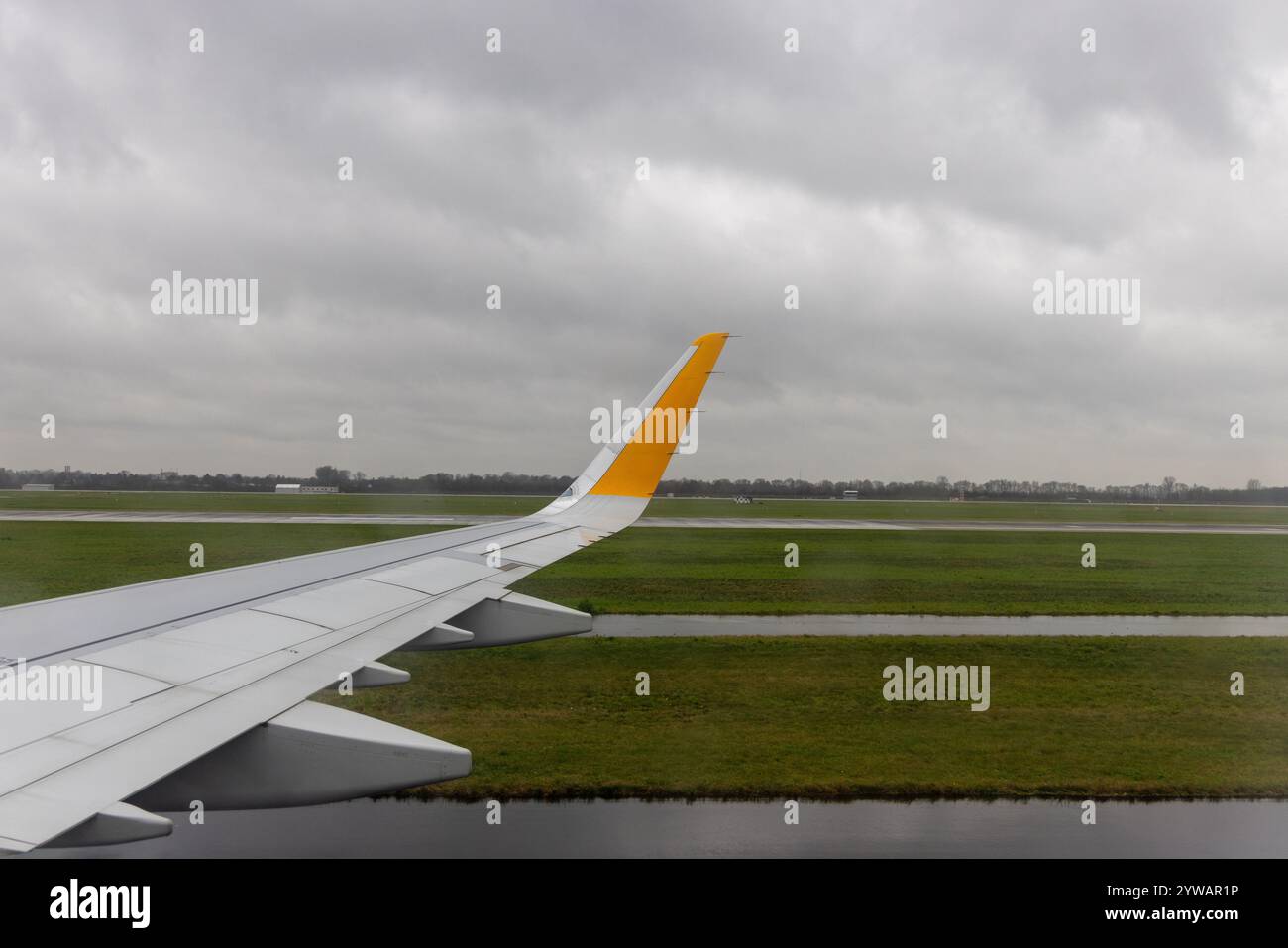 An airplane wing photographed during landing or takeoff on a cloudy day ...