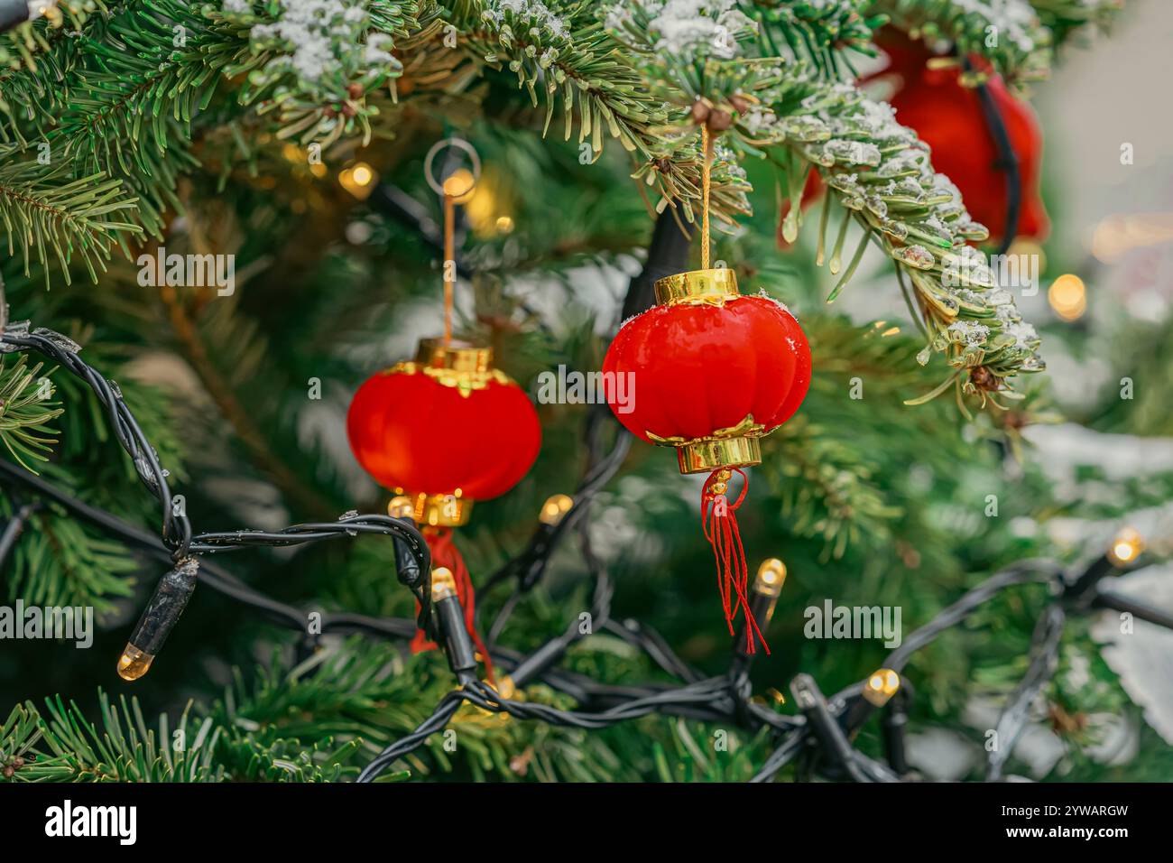 Close-up of green Christmas tree with mini red lanterns and festive ...