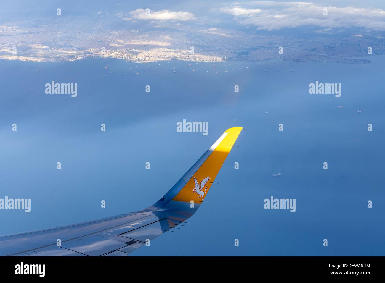 A high-resolution photo of a plane wing and blue sky viewed through an ...