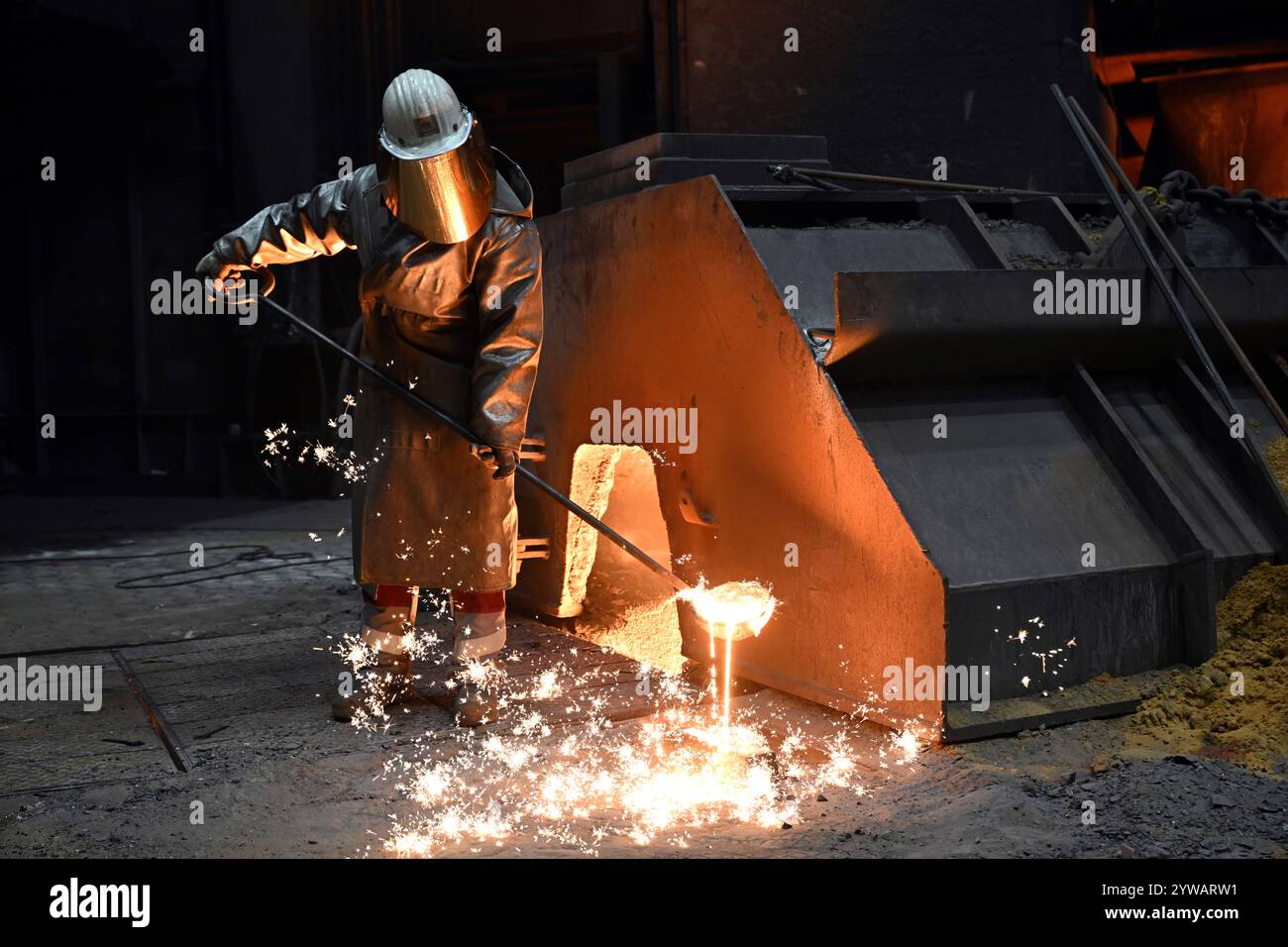 A worker takes a sample of molten pig iron at a blast furnace at the ...
