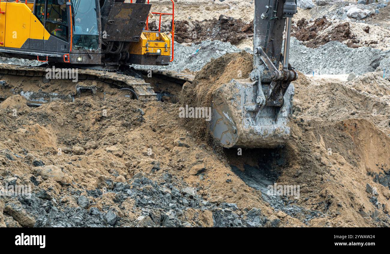 Close-up view of an excavator bucket excavating soil Stock Photo - Alamy