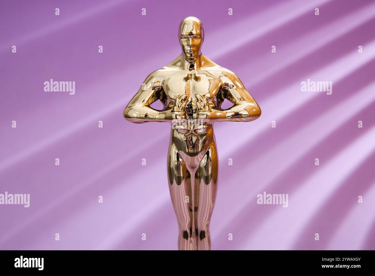 Golden trophy in shape of human figure on violet background Stock Photo ...
