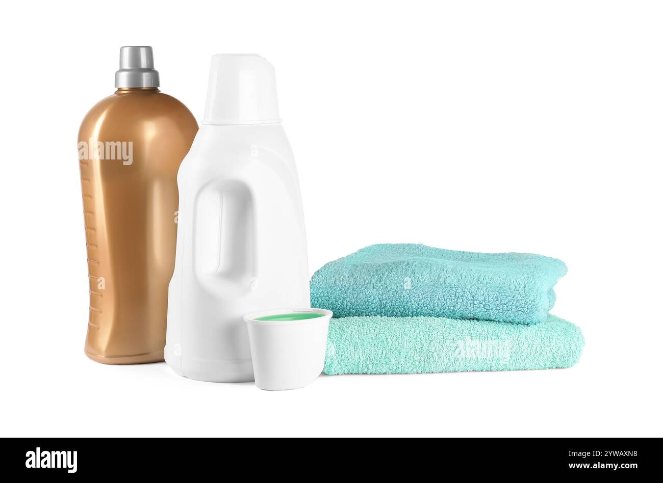 Bottles with laundry detergent, cap and clean towels isolated on white ...