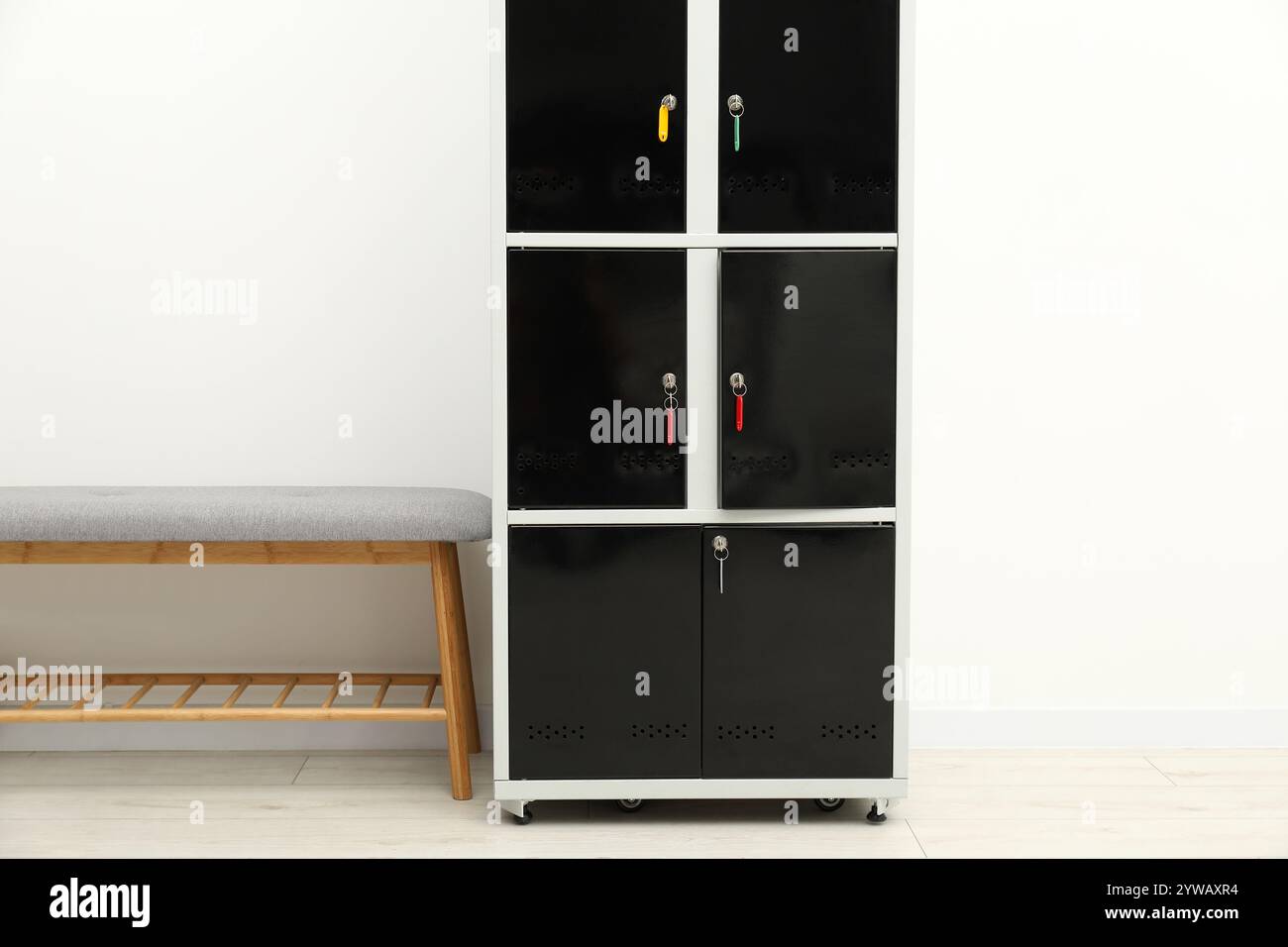 Locker with keys and bench near light wall Stock Photo - Alamy