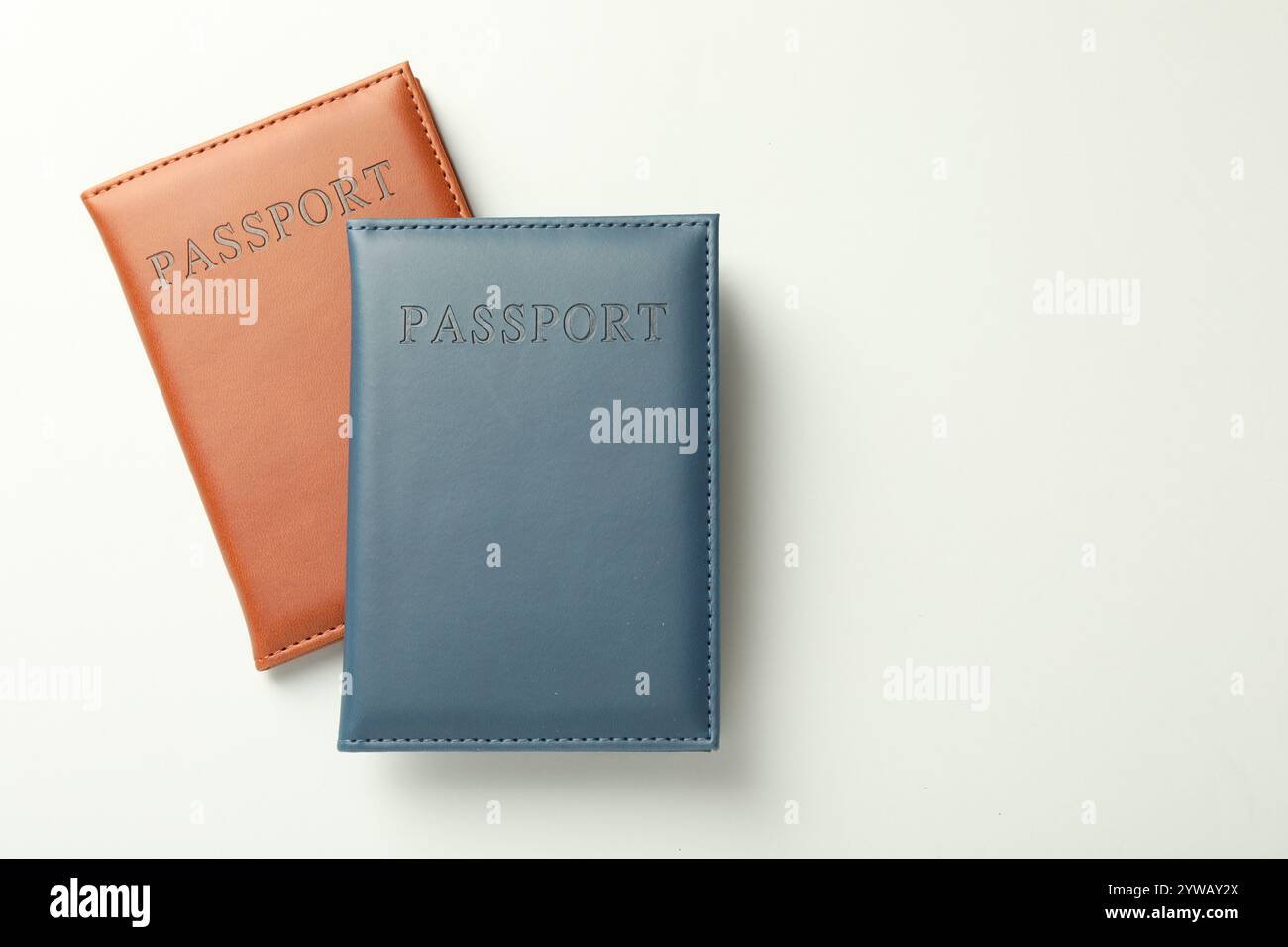 Passports in color covers on light background, top view. Space for text ...