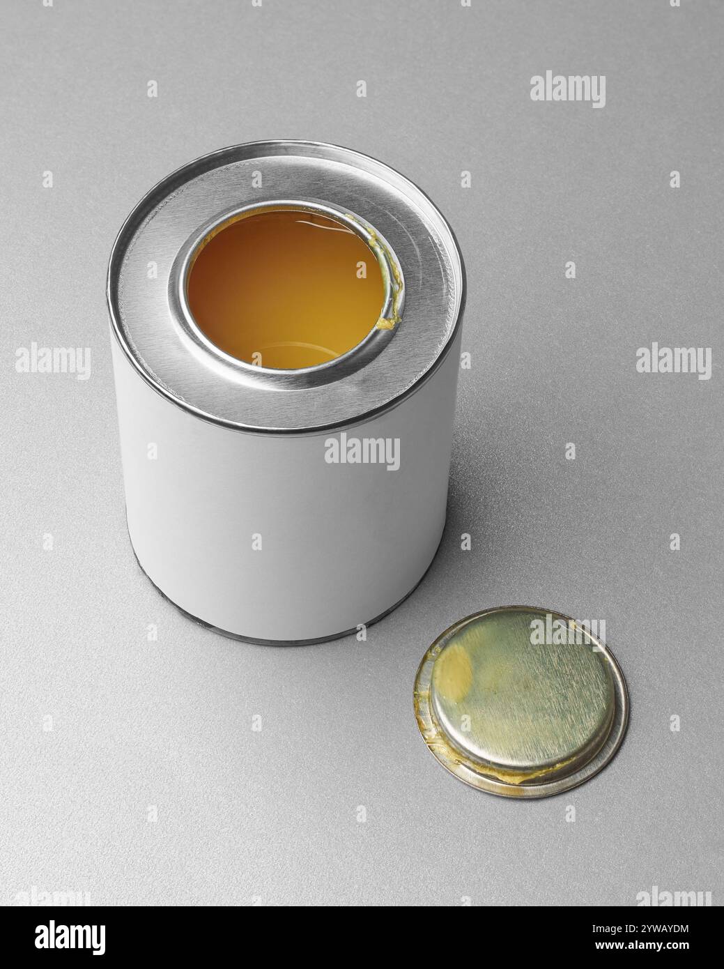strong yellow adhesive in silver tin can with lid opened isolated gray ...