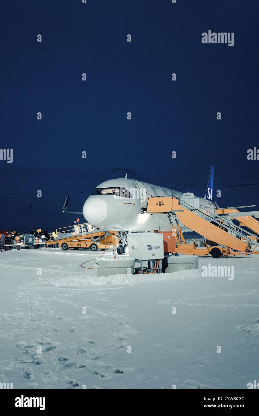 Aeroplane on snowy runway at night at Longyearbyen airport, Svalbard ...