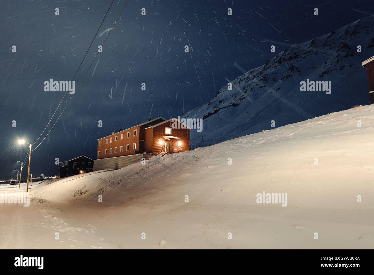 Wooden building in the snow at night in Nybyen, Longyearbyen, Svalbard ...