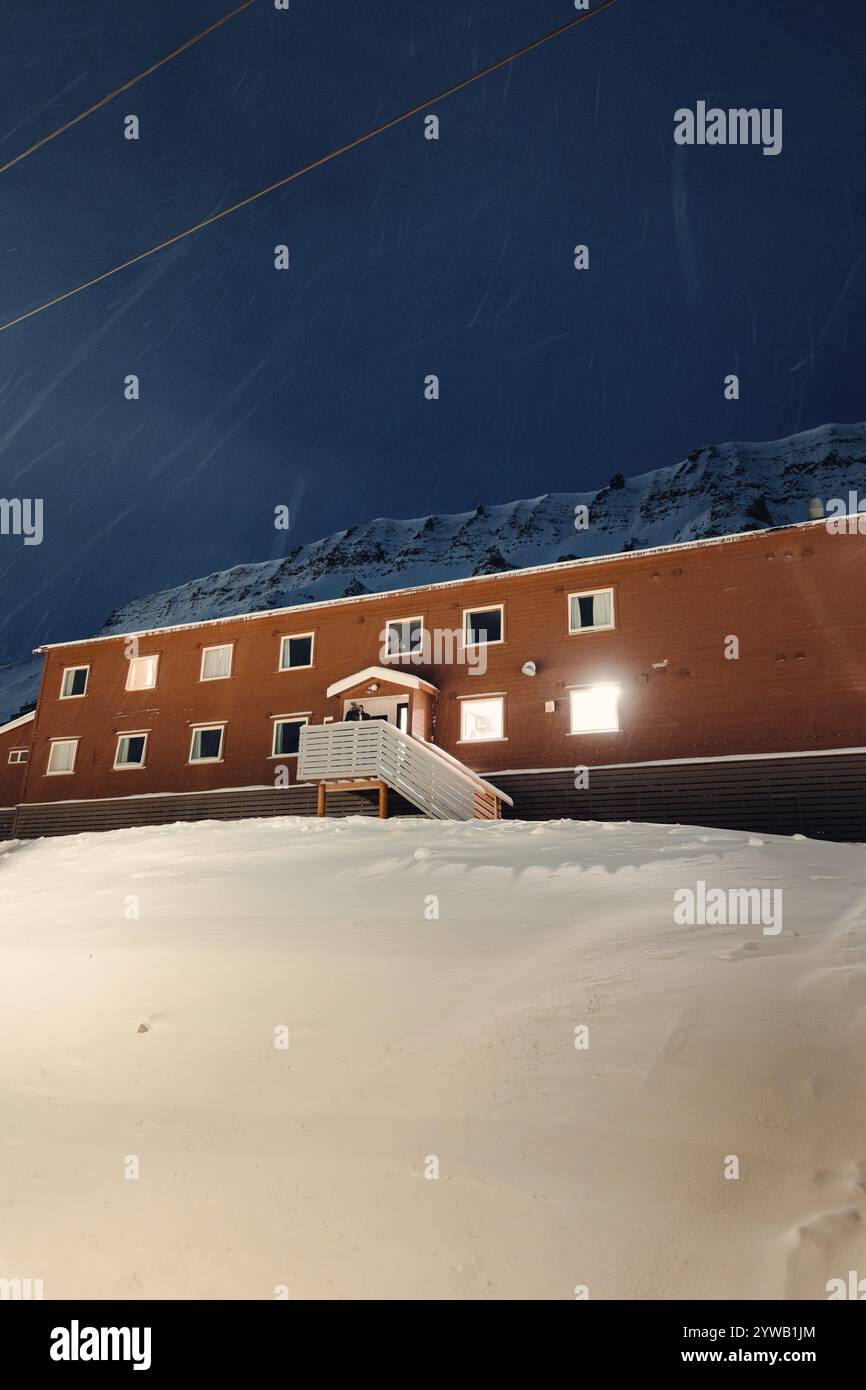 Brown apartment building in the snow in the polar night in Longyearbyen ...