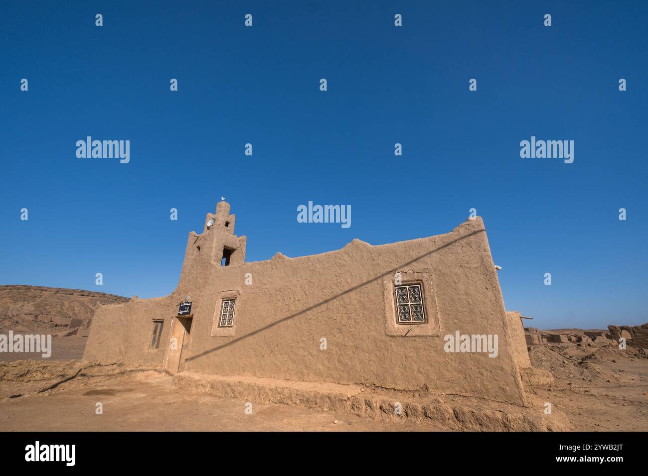 A mosque made of adobe bricks and mud in the sun of the Moroccan desert ...