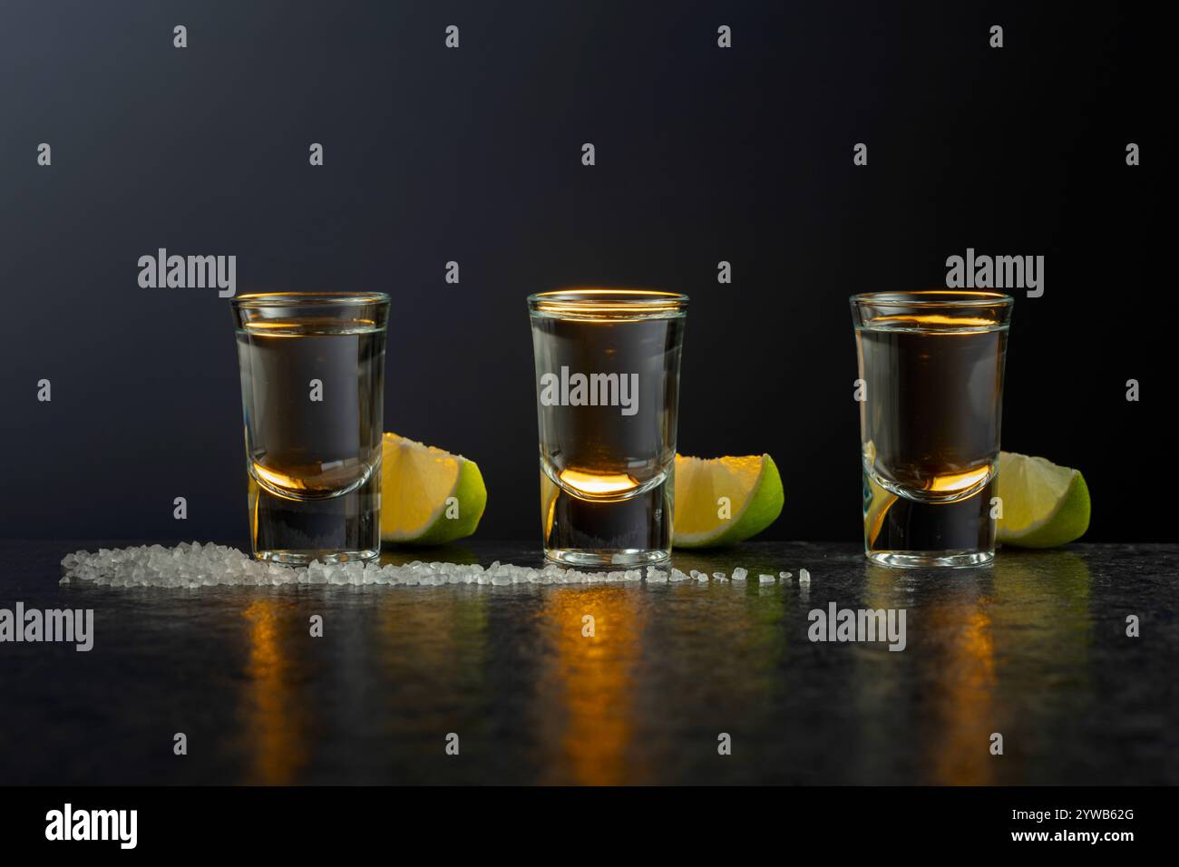 Mexican Tequila with lime and salt on a stone table. Dark background ...