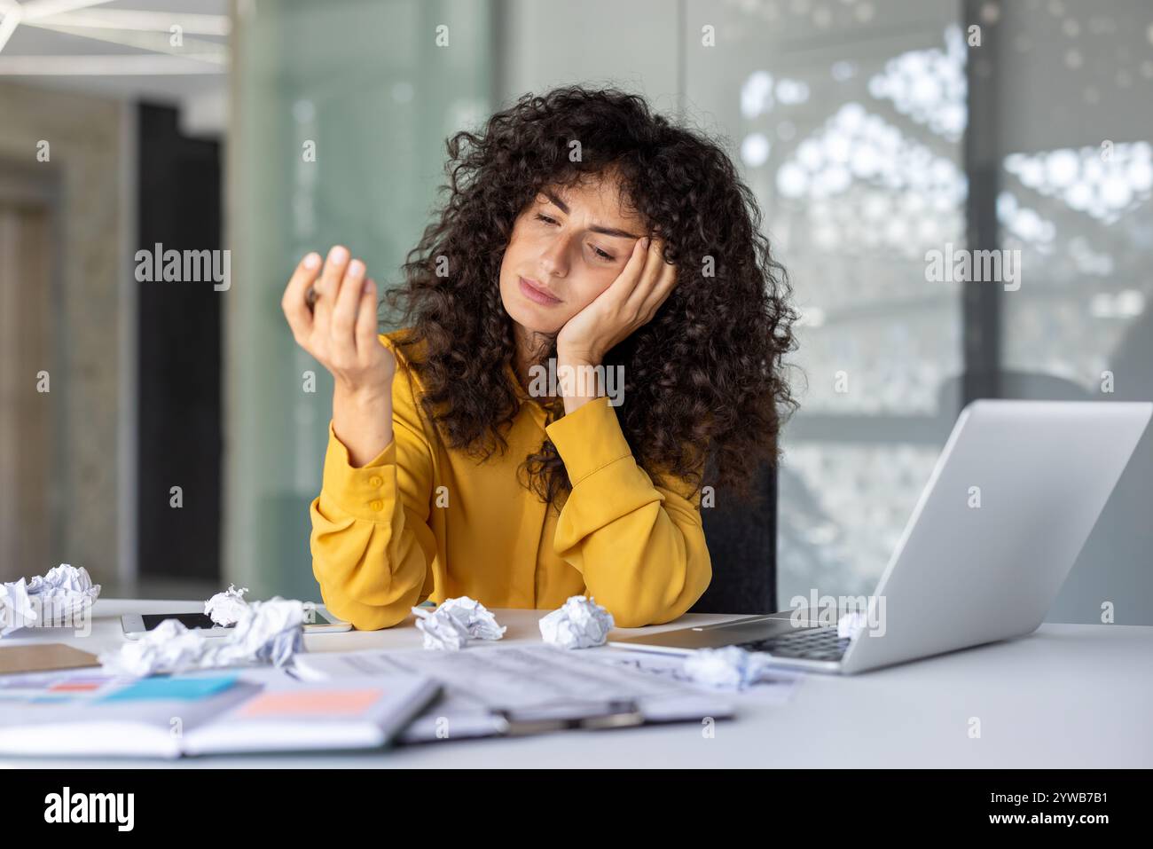 An office worker, overwhelmed by paperwork, shows frustration at her ...