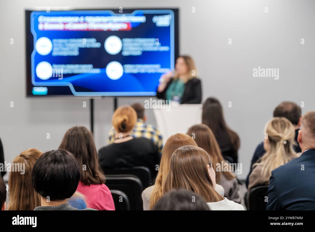 Blurred speaker in business conference room engaging audience with ...