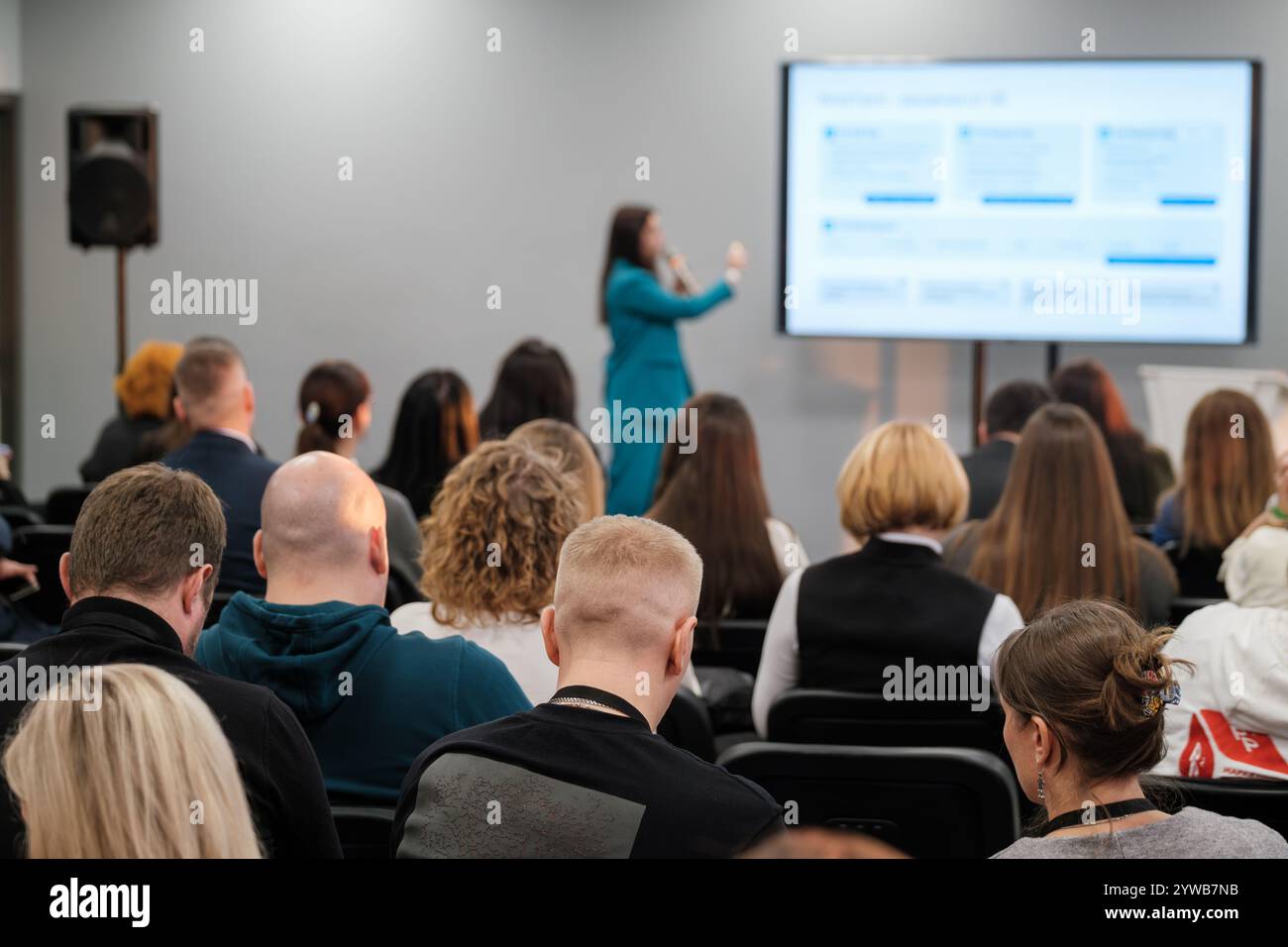 Audience engaged during a presentation with speaker using a microphone ...