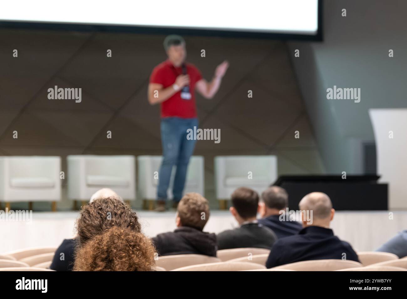 Motivational speaker presenting on stage to attentive audience during ...