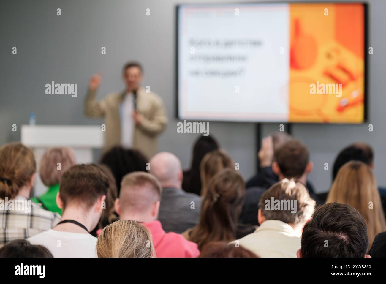 Professional speaking at conference room engaging audience with ...