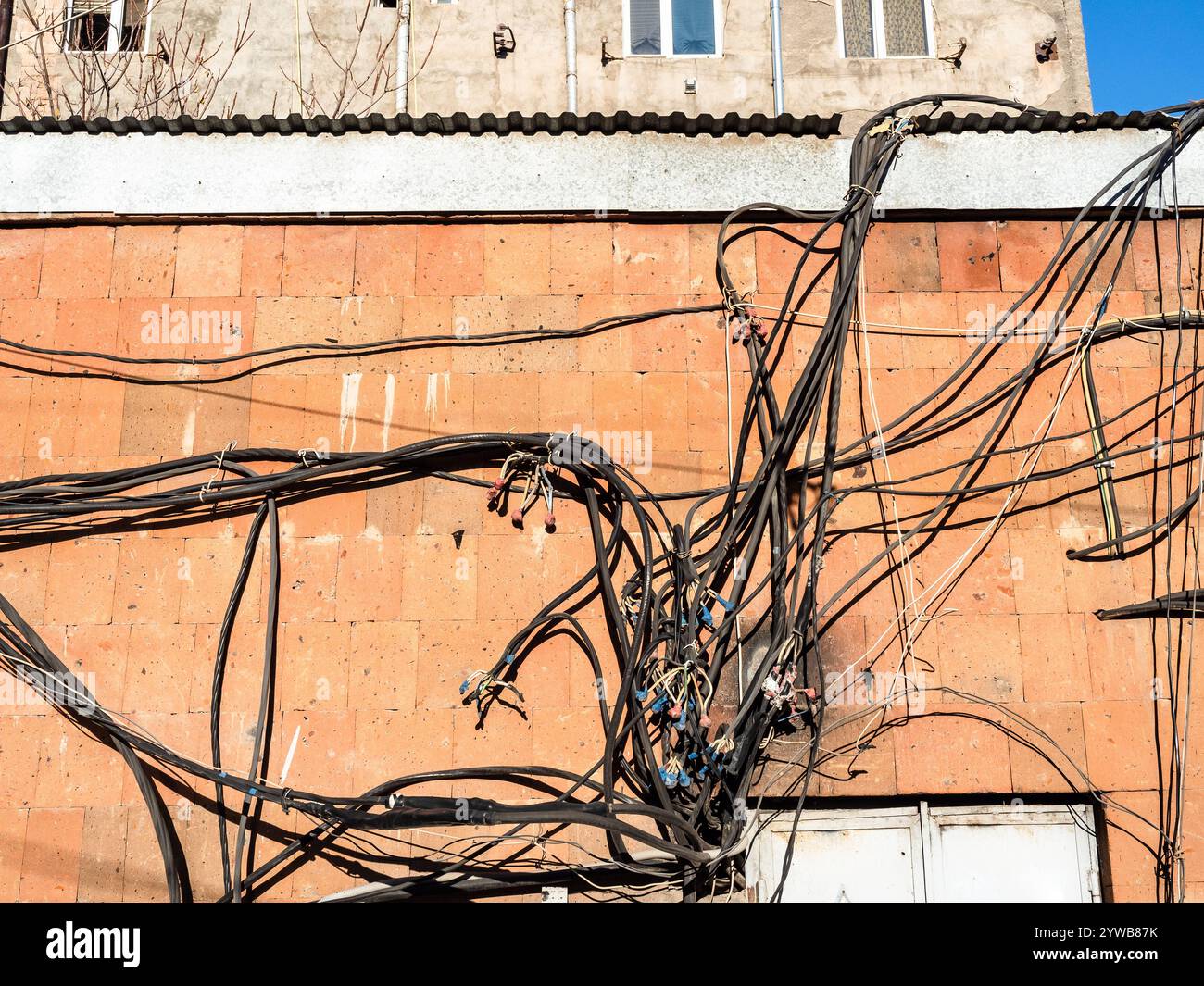 lot of tangled electrical cables and wires on outdoor wall of building ...