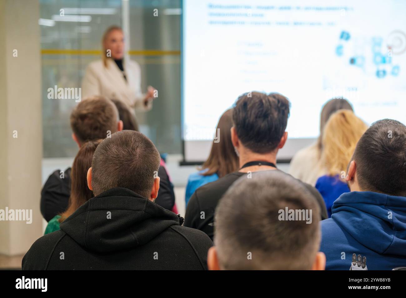 Business seminar with audience focused on presentation by speaker ...