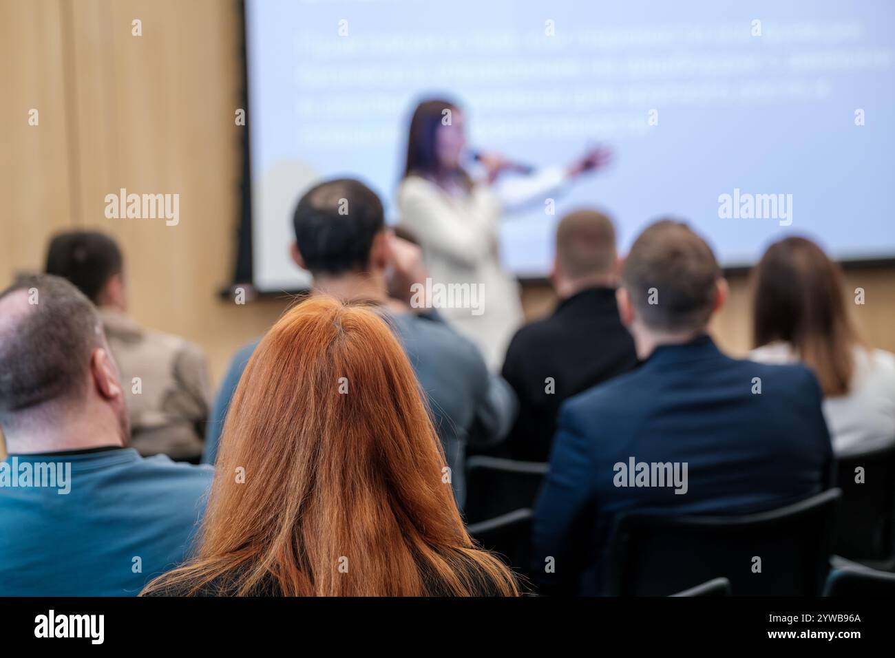 People attending a business presentation, watching speaker deliver an ...