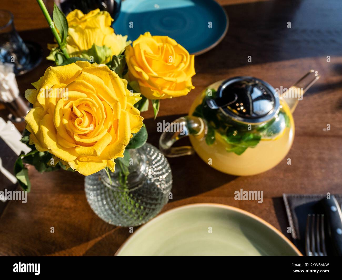 fresh yellow roses on served table with glass teapot Stock Photo - Alamy