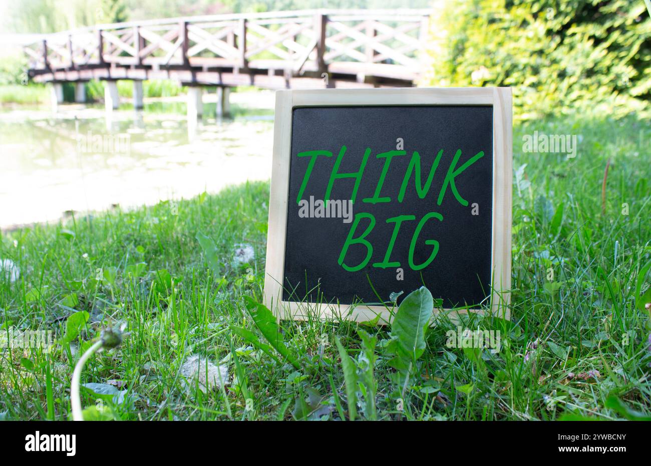 Think big symbol. Concept words Think Big on black chalk background ...