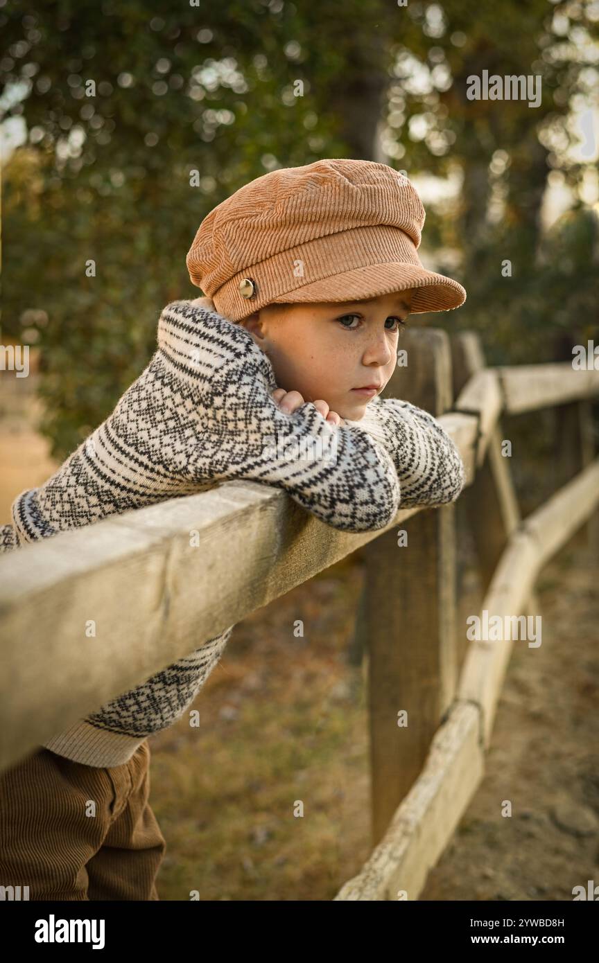 boys from the countryside is watching foe a horses and riders on a farm ...