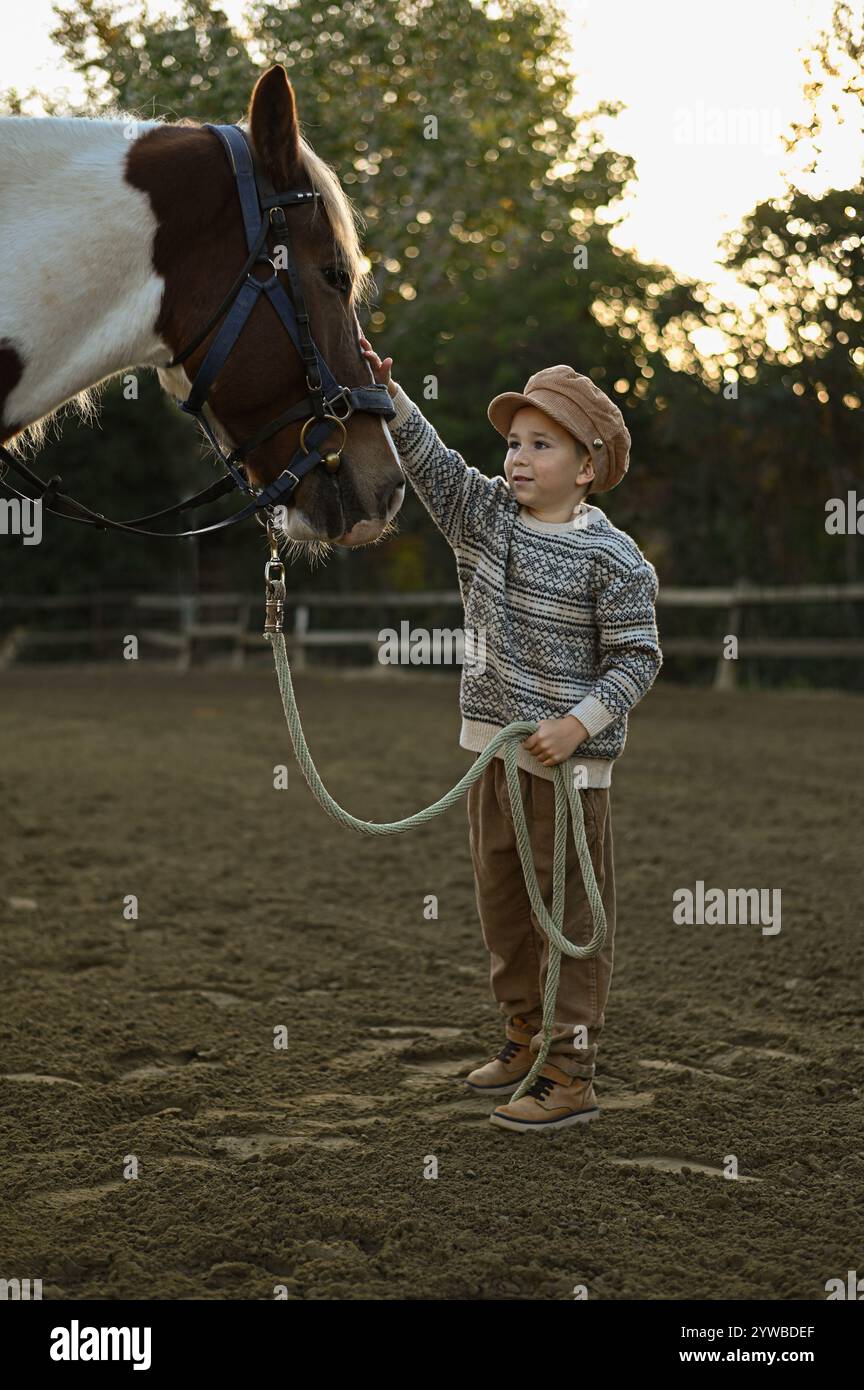 boys from the countryside is watching foe a horses and riders on a farm ...
