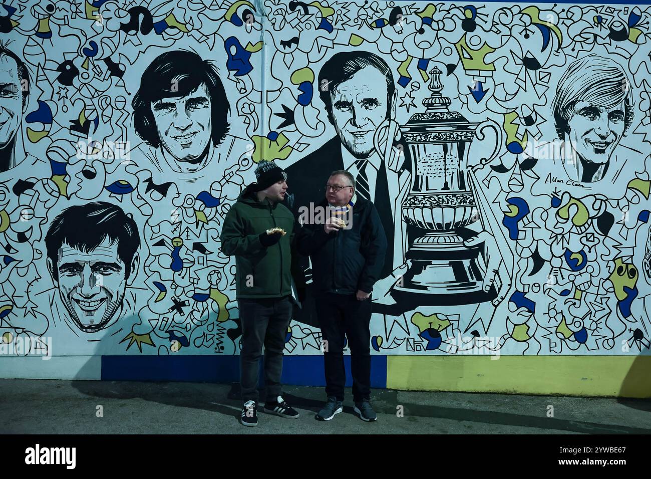 Fans grab a bite to eat on the Leeds United history wall during the Sky ...