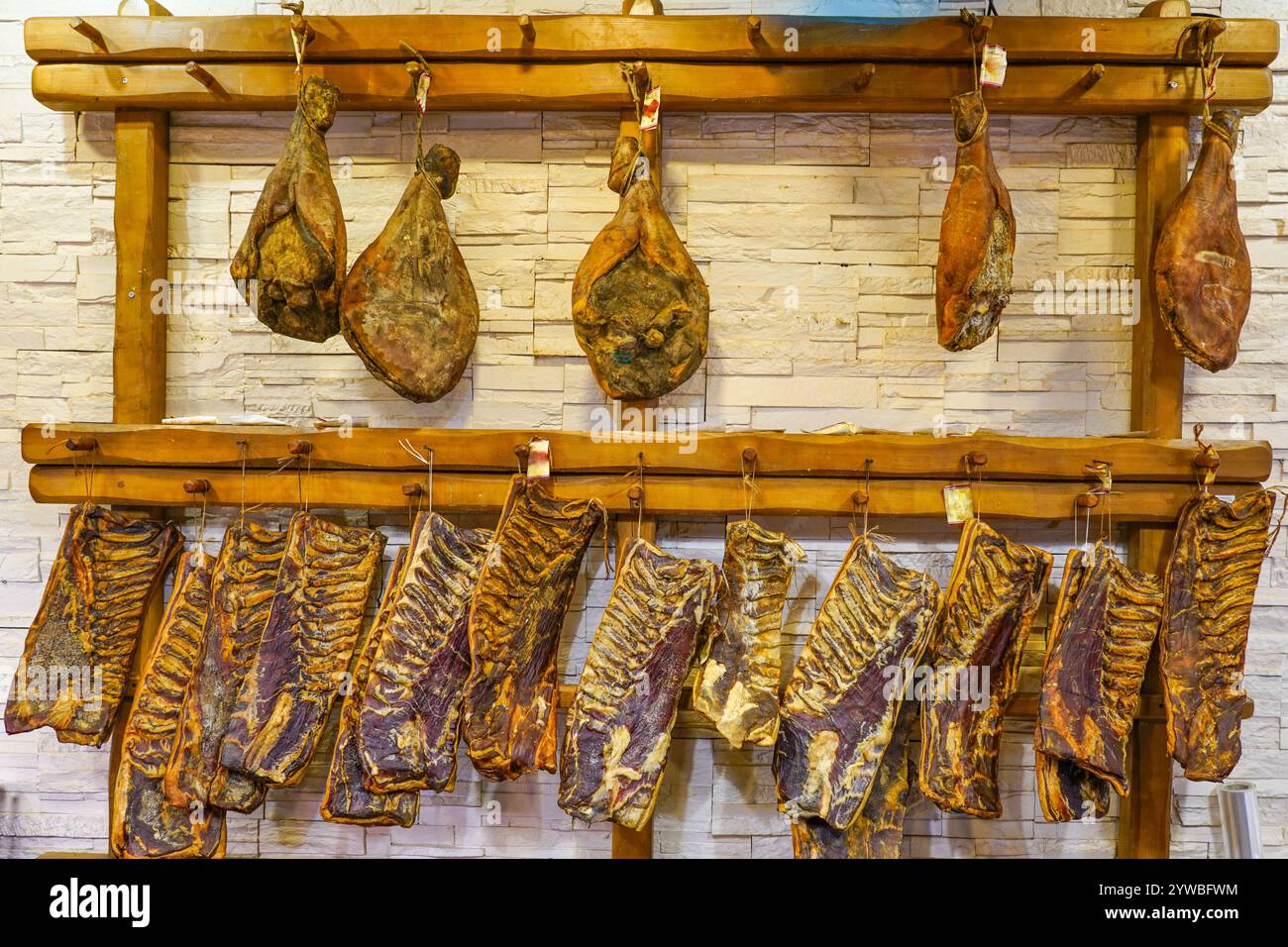 Dried and smoked hams and ribs hang in a traditional butcher shop in a ...