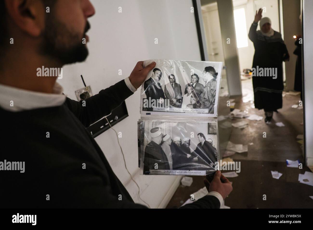 A man shows old pictures of the late Syrian President Hafez Assad as ...