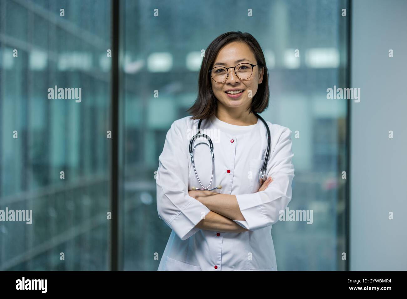 Asian woman doctor confidently stands with arms crossed, showcasing ...