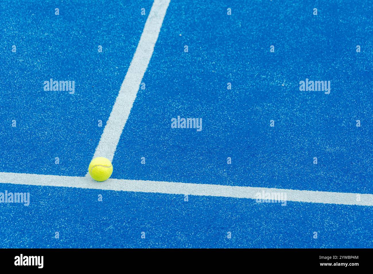 a ball on the line in a blue paddle tennis court Stock Photo - Alamy
