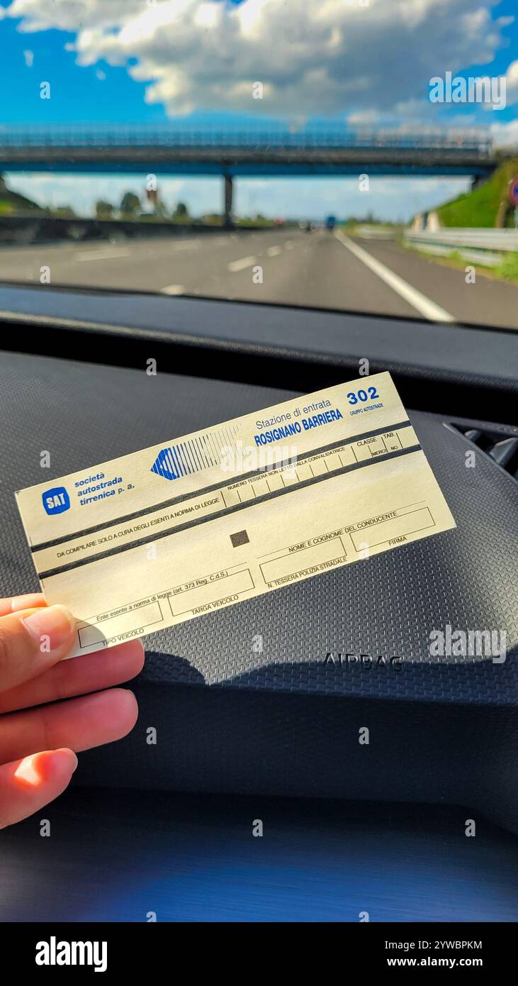 Woman's hand holds ticket of Toll Road operated by Societa Autostrada ...