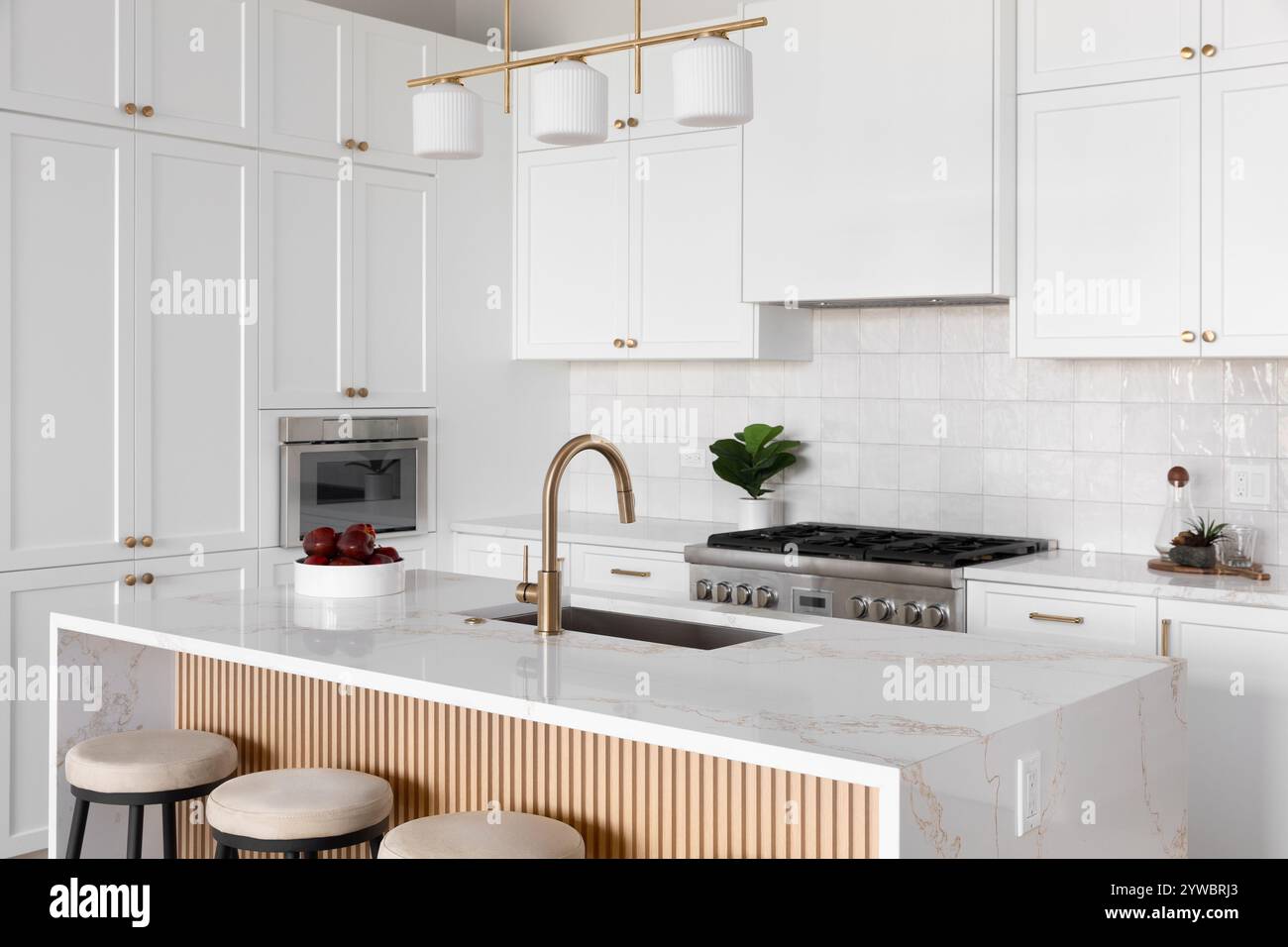 A kitchen detail with white cabinets and square tile backsplash, a ...