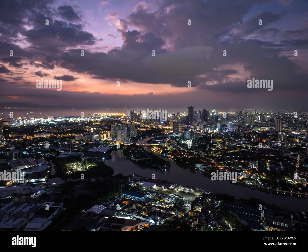 Manila skyline and Pasig River illuminated by a stunning sunset, with ...