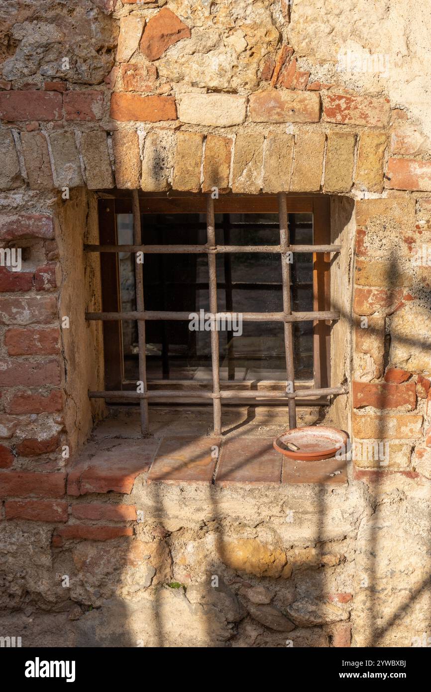 Barred window in a building in the medieval walled town of ...