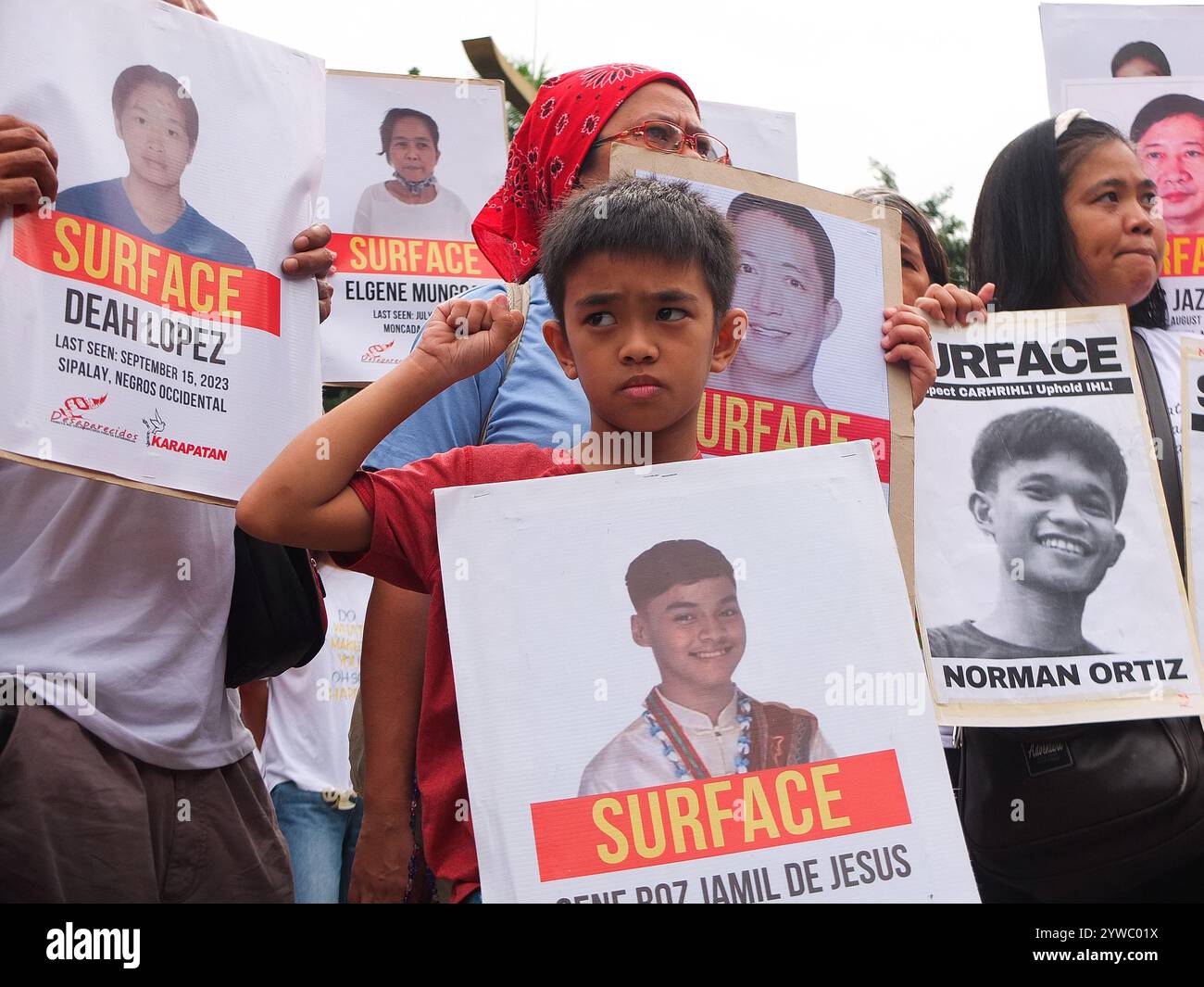 A young boy also join the protest holding a portrait of his relative ...