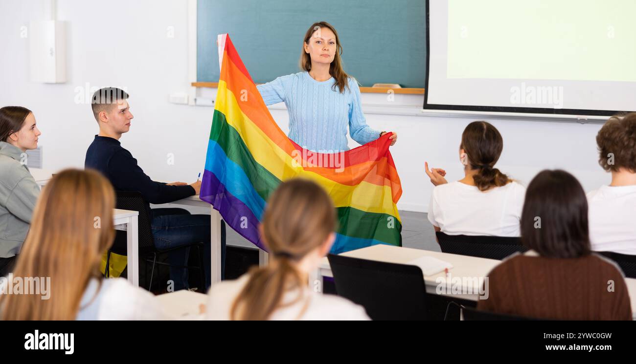 Adult female teacher showing LGBT flag to students Stock Photo - Alamy