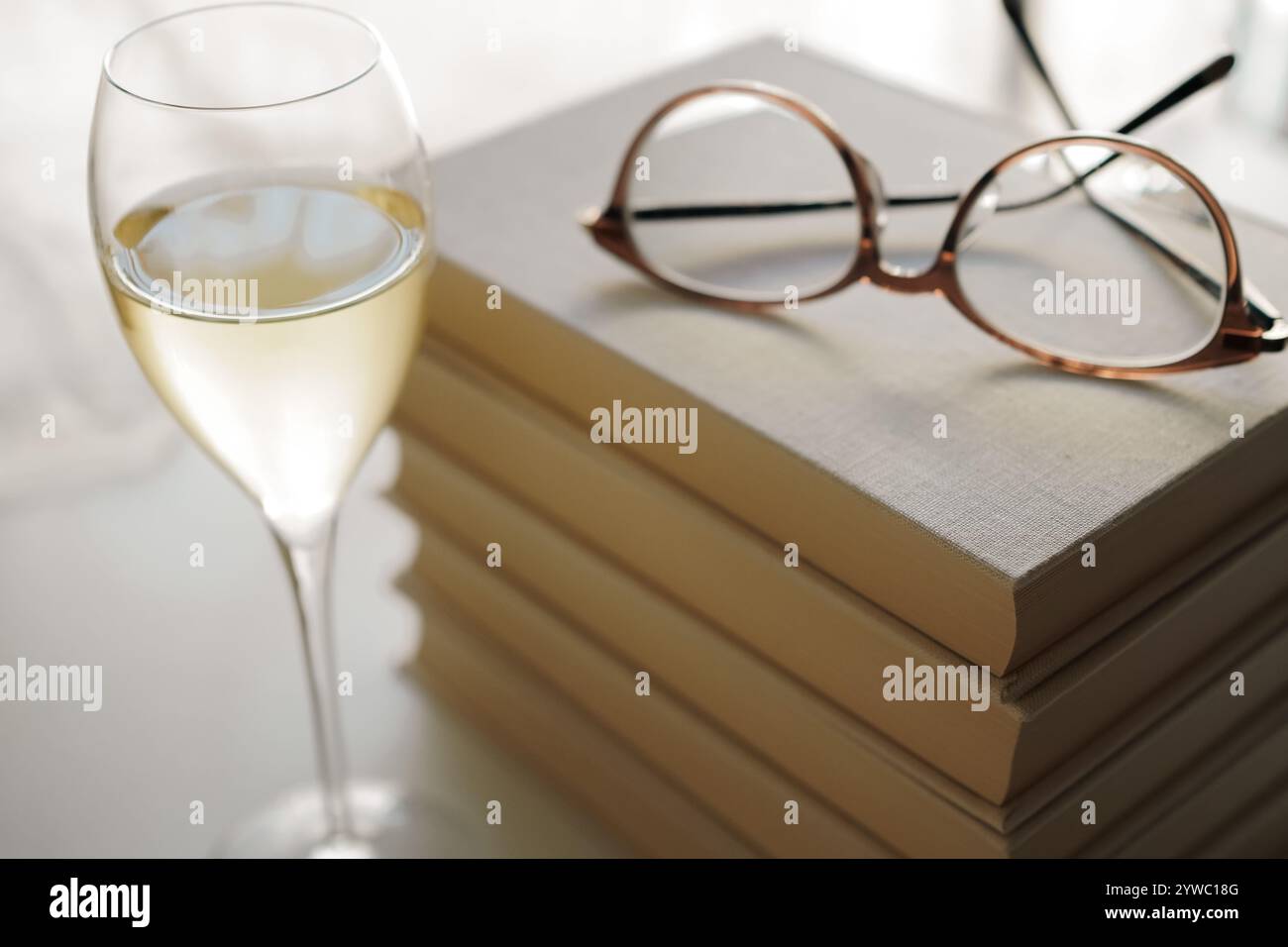 Glasses on top of a stack of books and a glass of white wine Stock ...