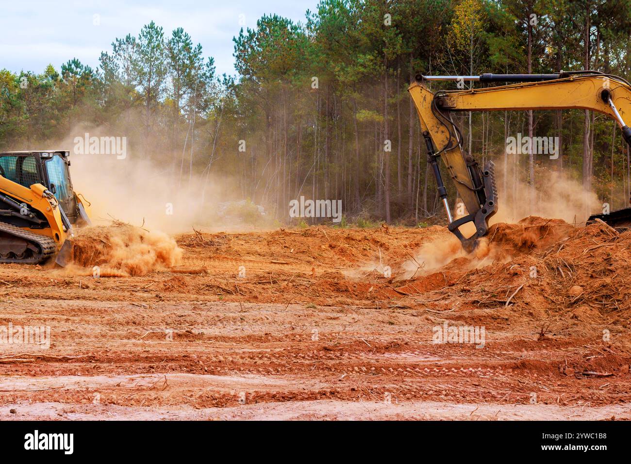 During excavation an earthmoving small mini tractor is leveling ground ...